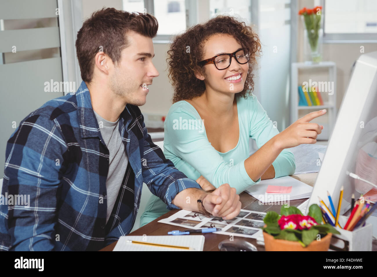 Creative businesswoman pointing at computer monitor Stock Photo - Alamy