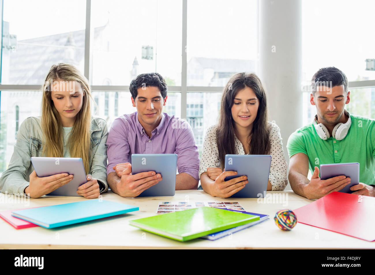 Students using tablets sitting in a line Stock Photo - Alamy