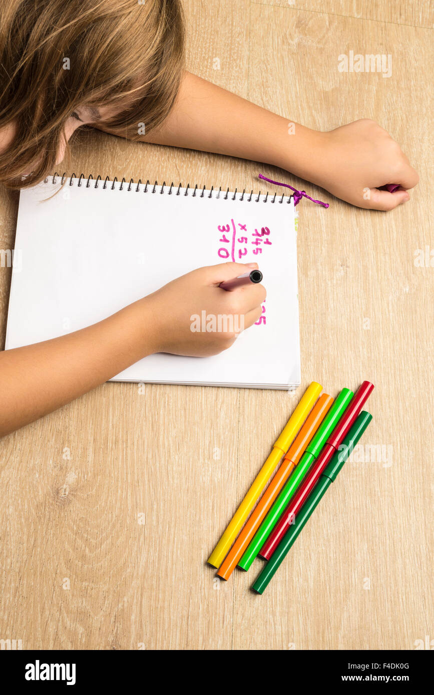Little girl doing homework lying on the floor Stock Photo - Alamy