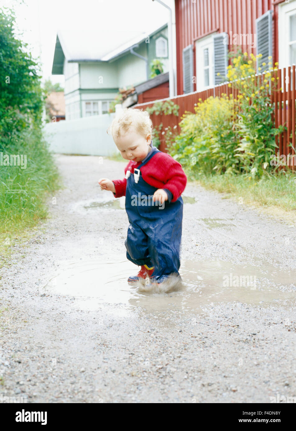 A small girl splashing in a puddle Stock Photo - Alamy