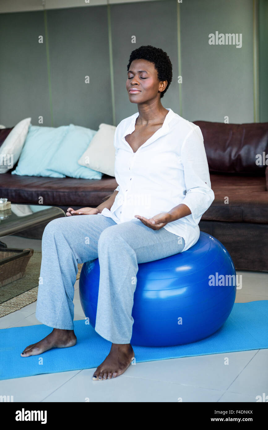 Relaxed woman sitting on exercise ball Stock Photo - Alamy