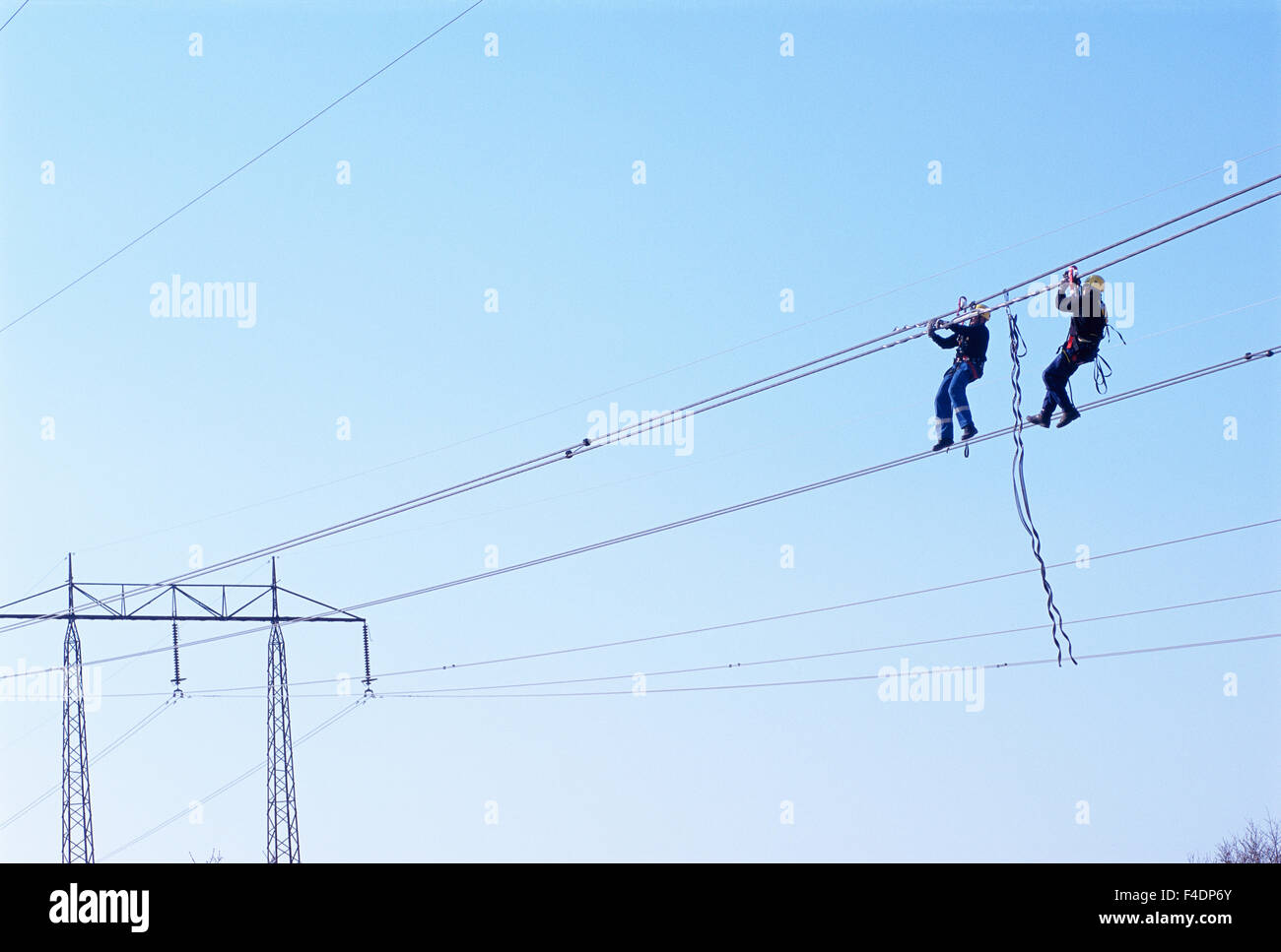 Men walking on cable, low angle view Stock Photo - Alamy