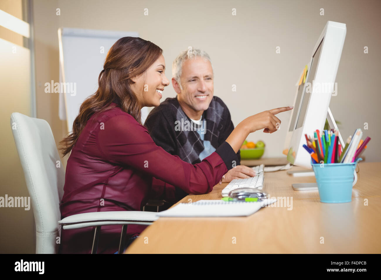Businesswoman pointing at computer screen in office Stock Photo - Alamy
