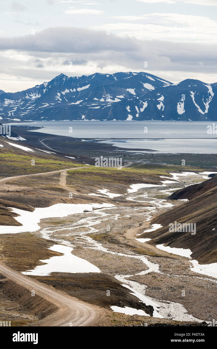Russia, Chukotka, Provideniya, Patchy snow in riverbed flowing into ...