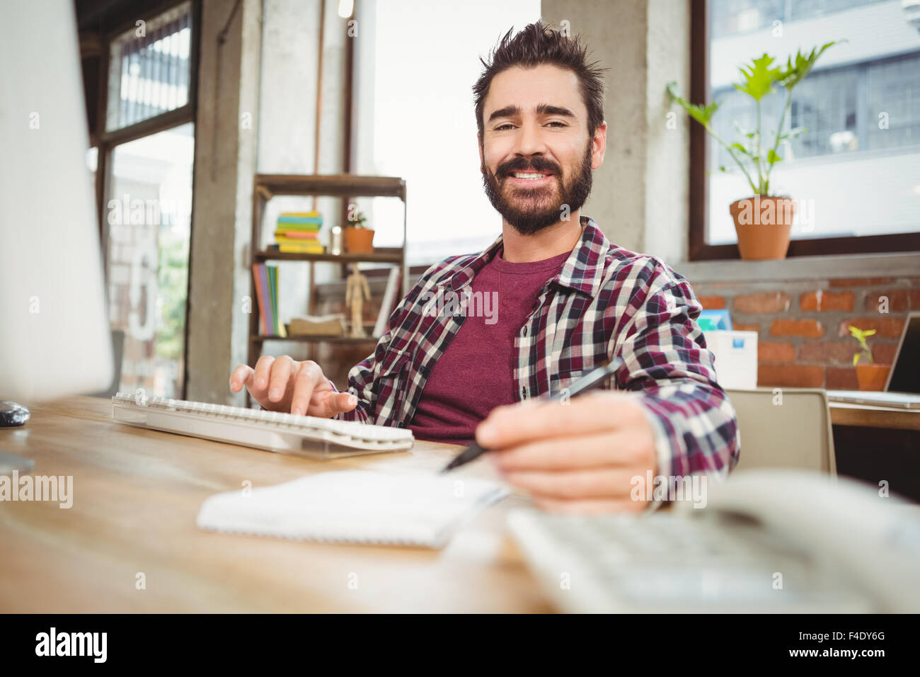 Happy businessman working while writing at office Stock Photo - Alamy