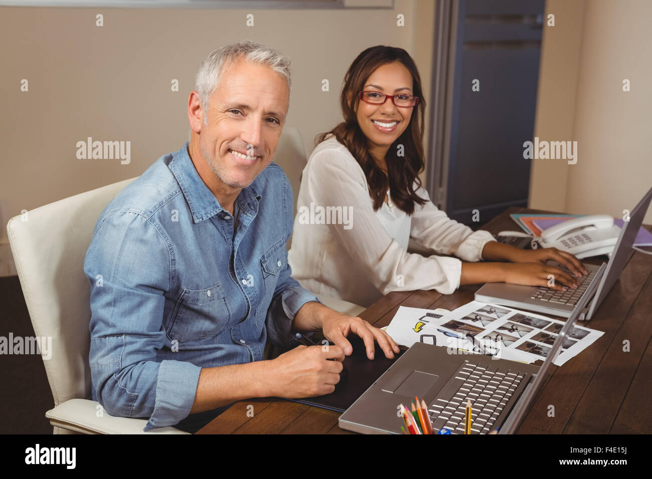 Creative business people working with laptop at desk in office Stock ...