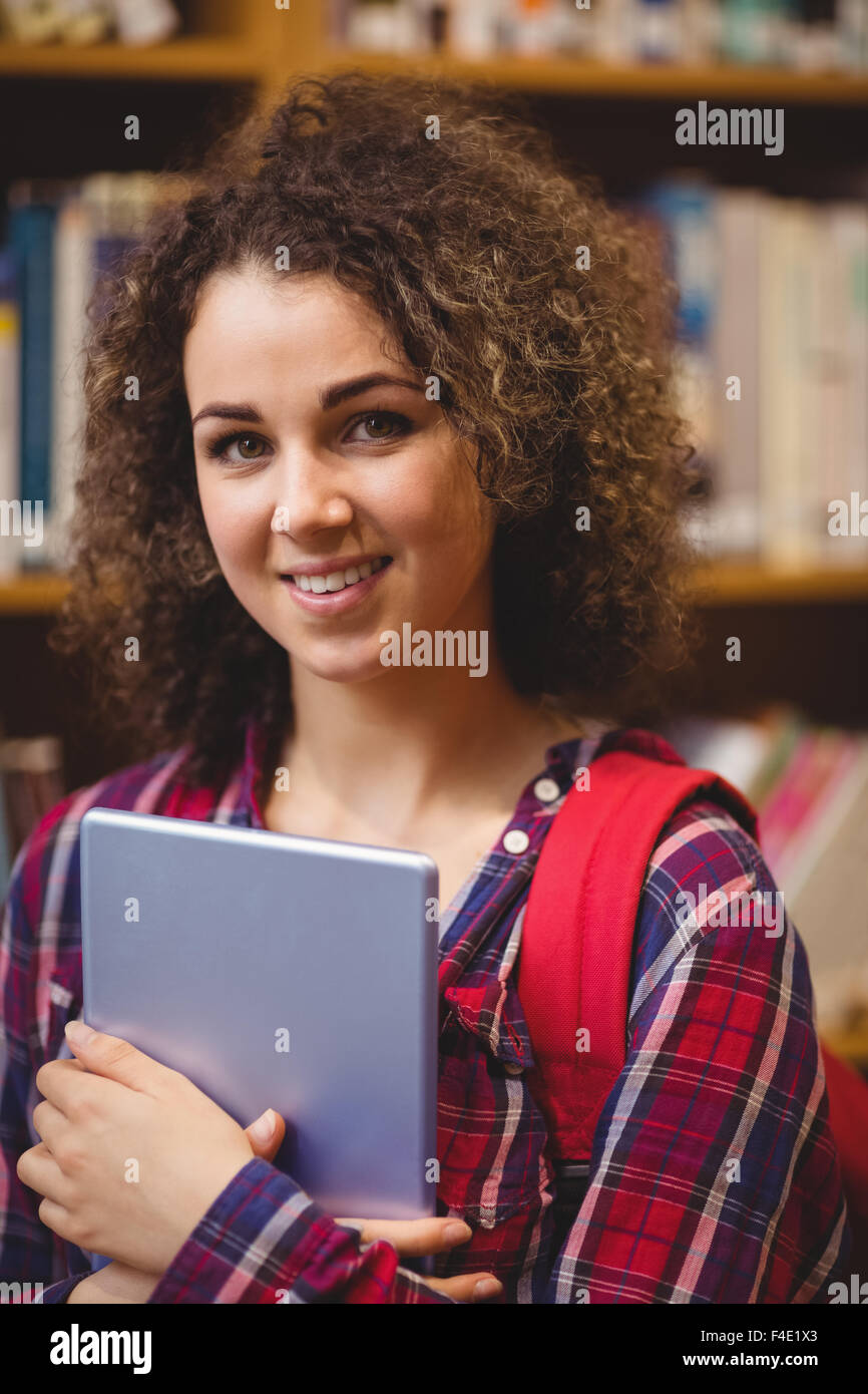 Pretty student in the library with tablet Stock Photo - Alamy