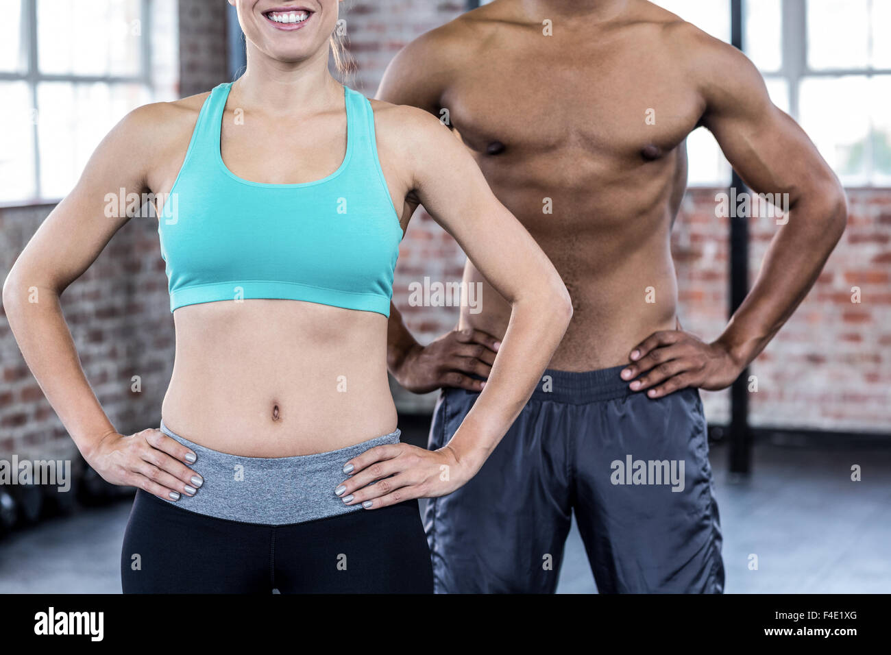 Fit couple with hands on the hips Stock Photo - Alamy