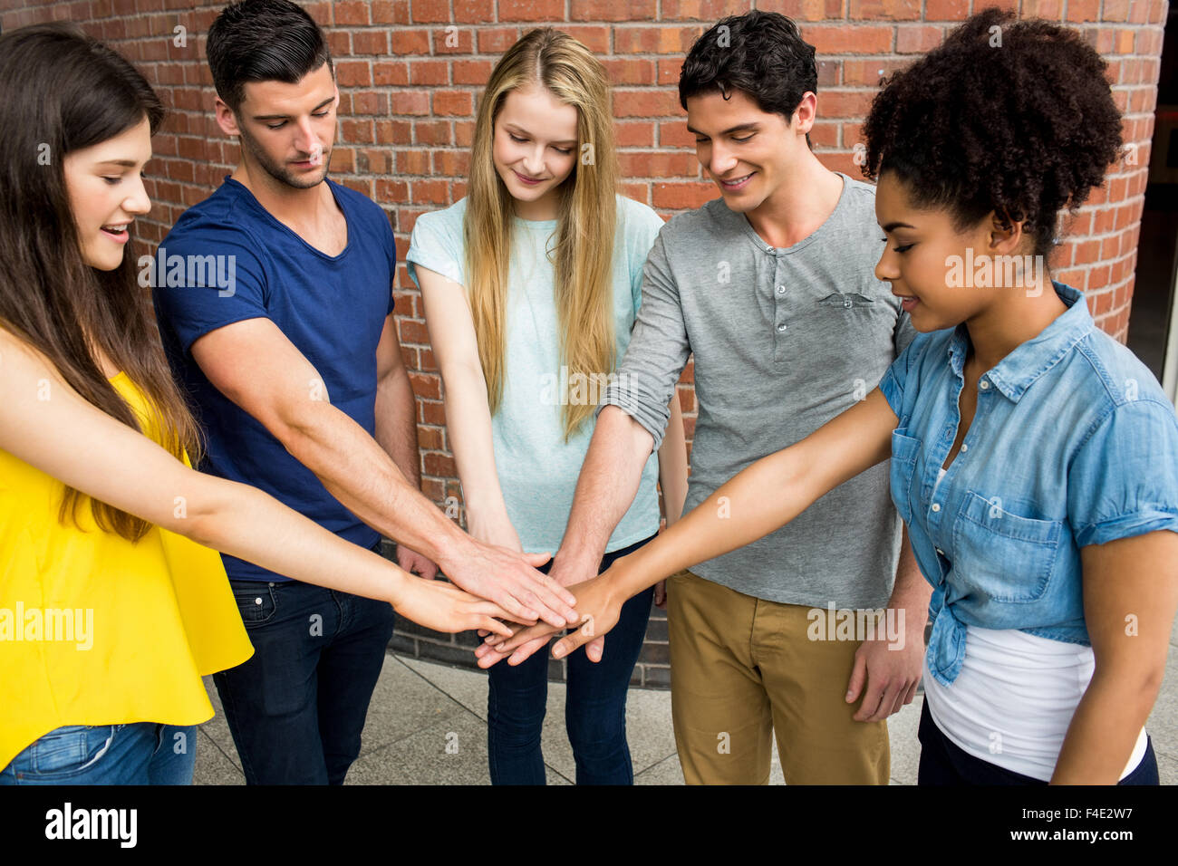 Students putting hands together in unity Stock Photo - Alamy