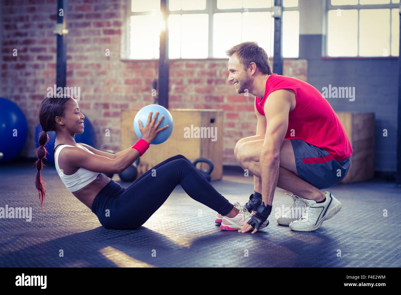 Muscular couple doing abdominal ball exercise Stock Photo - Alamy