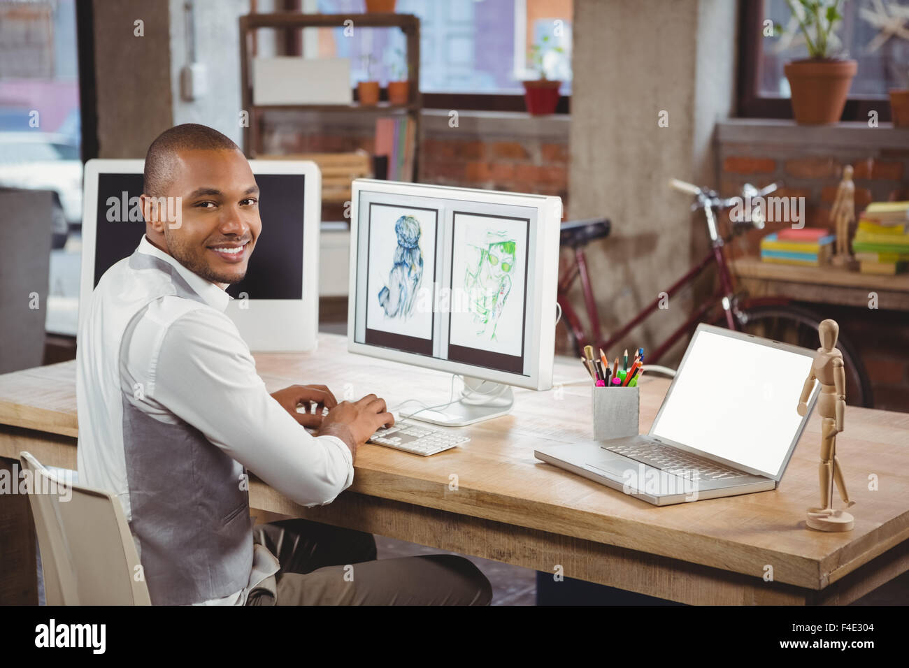 Smiling cartoonist working on computer Stock Photo - Alamy
