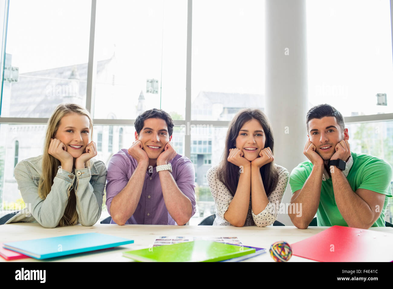 Students smiling at camera sitting in a line Stock Photo - Alamy
