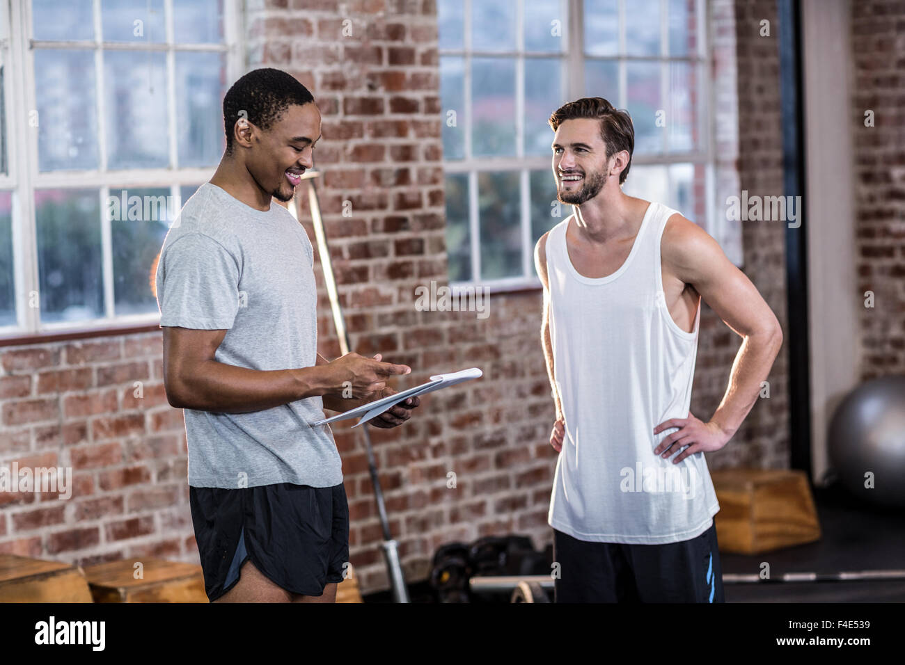 Smiling trainer writing on his clipboard Stock Photo - Alamy