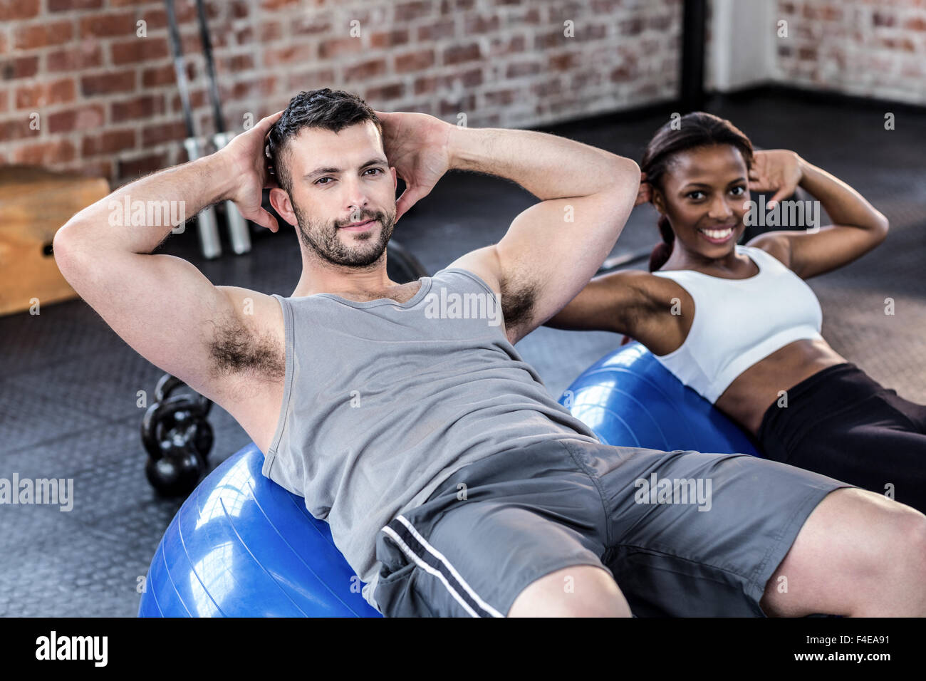 Fit man and woman doing sit ups on exercise ball Stock Photo - Alamy