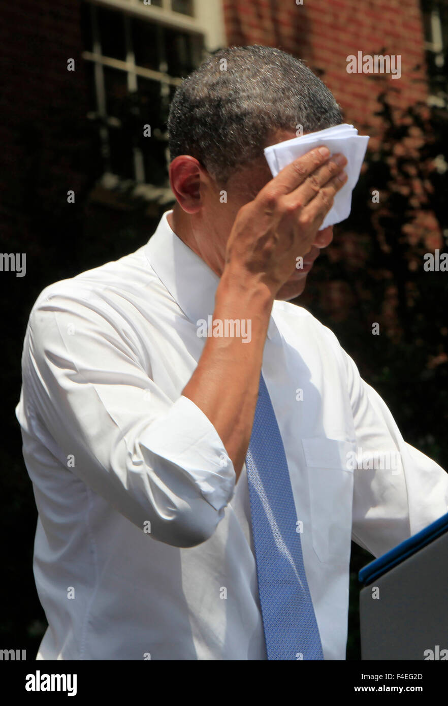 President Barack Obama wipes his face on a hot summer day as he makes a ...