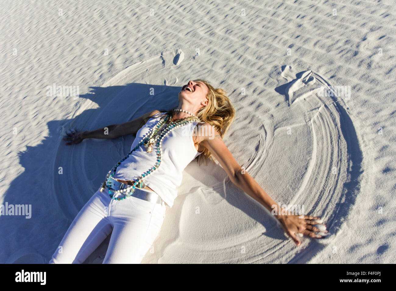 Alamogordo, New Mexico. Woman making sand angels in White Sands ...