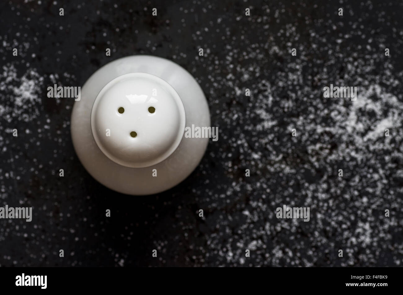 Ceramic salt shaker on black background top view Stock Photo - Alamy