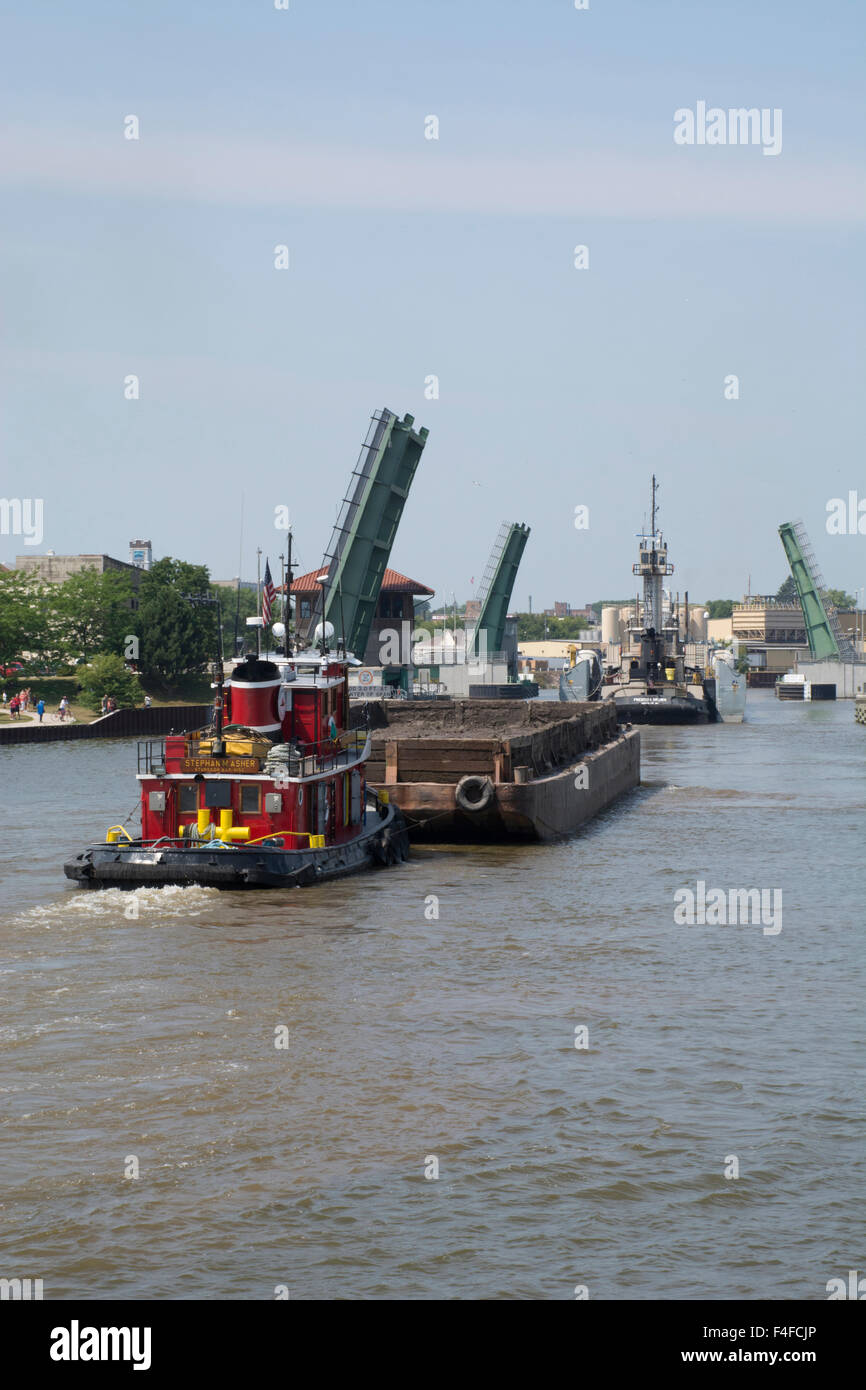 Wisconsin, Manitowoc. Manitowoc River. Tugboat and barge sailing up the ...