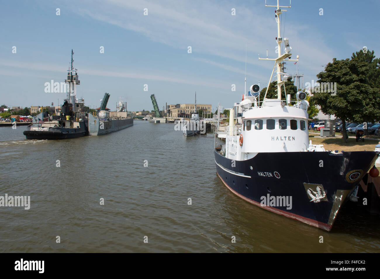 Wisconsin, Manitowoc. Manitowoc River. Tugboat pushing barge sailing up ...