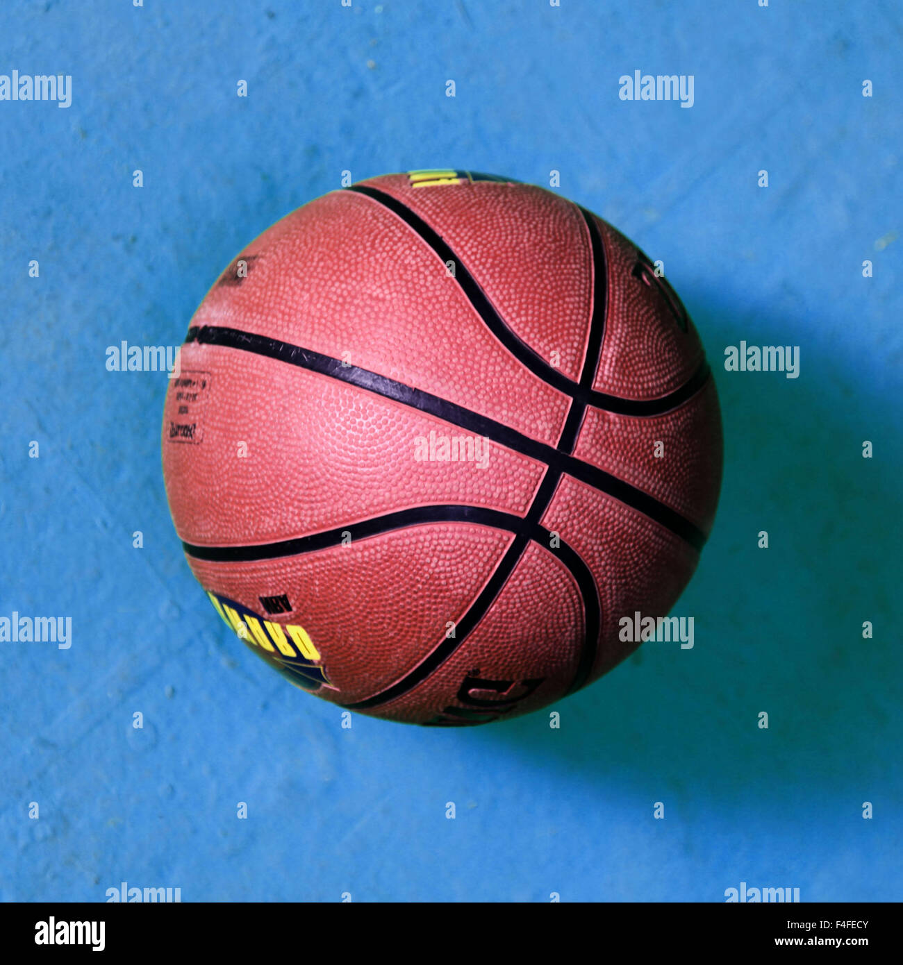 I's a photo of a Basketball ball top view on a blue floor in a sport ...