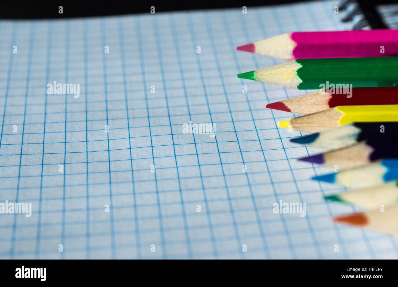 Colored pencils lying on an open notebook Stock Photo - Alamy