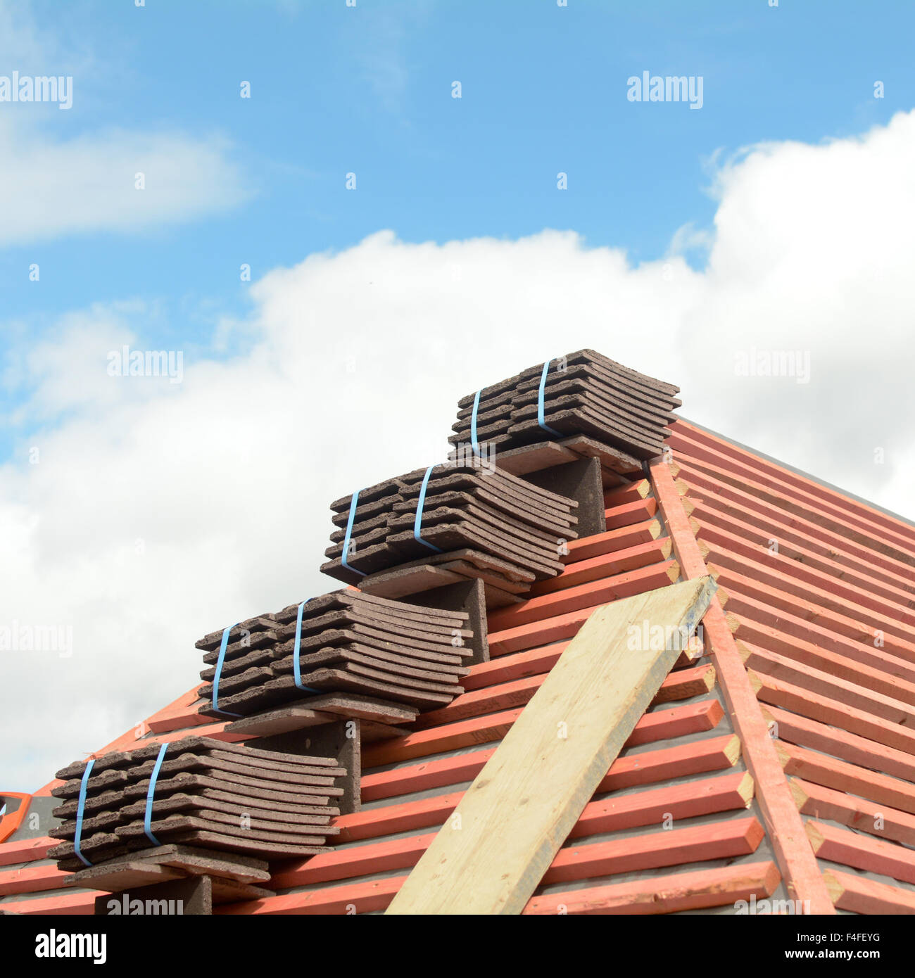 Stacks of roof tiles on roof ready for fitting to Victorian style home ...