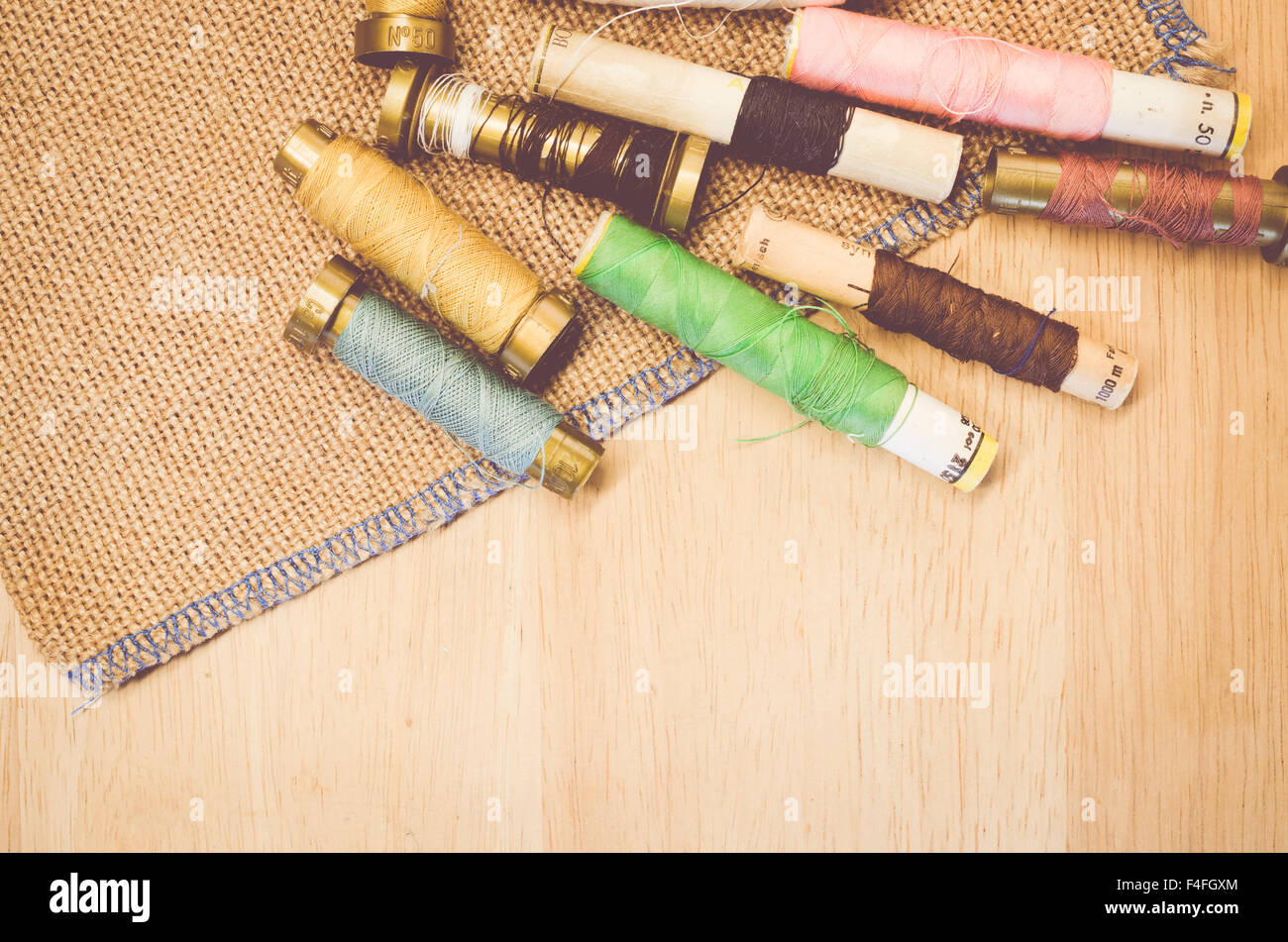 old sewing thread spools on burlap and wood background Stock Photo - Alamy