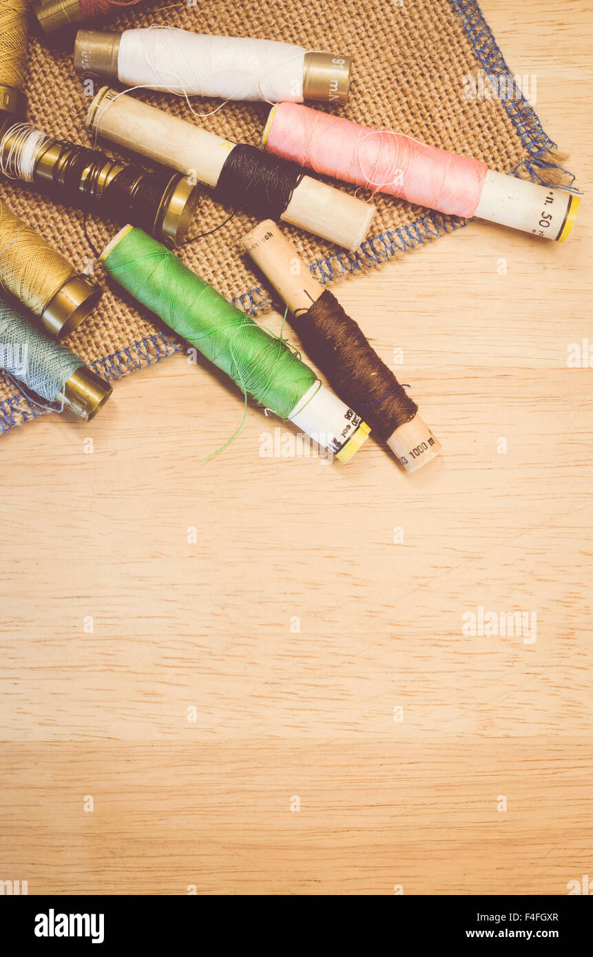 old sewing thread spools on burlap and wood background Stock Photo - Alamy