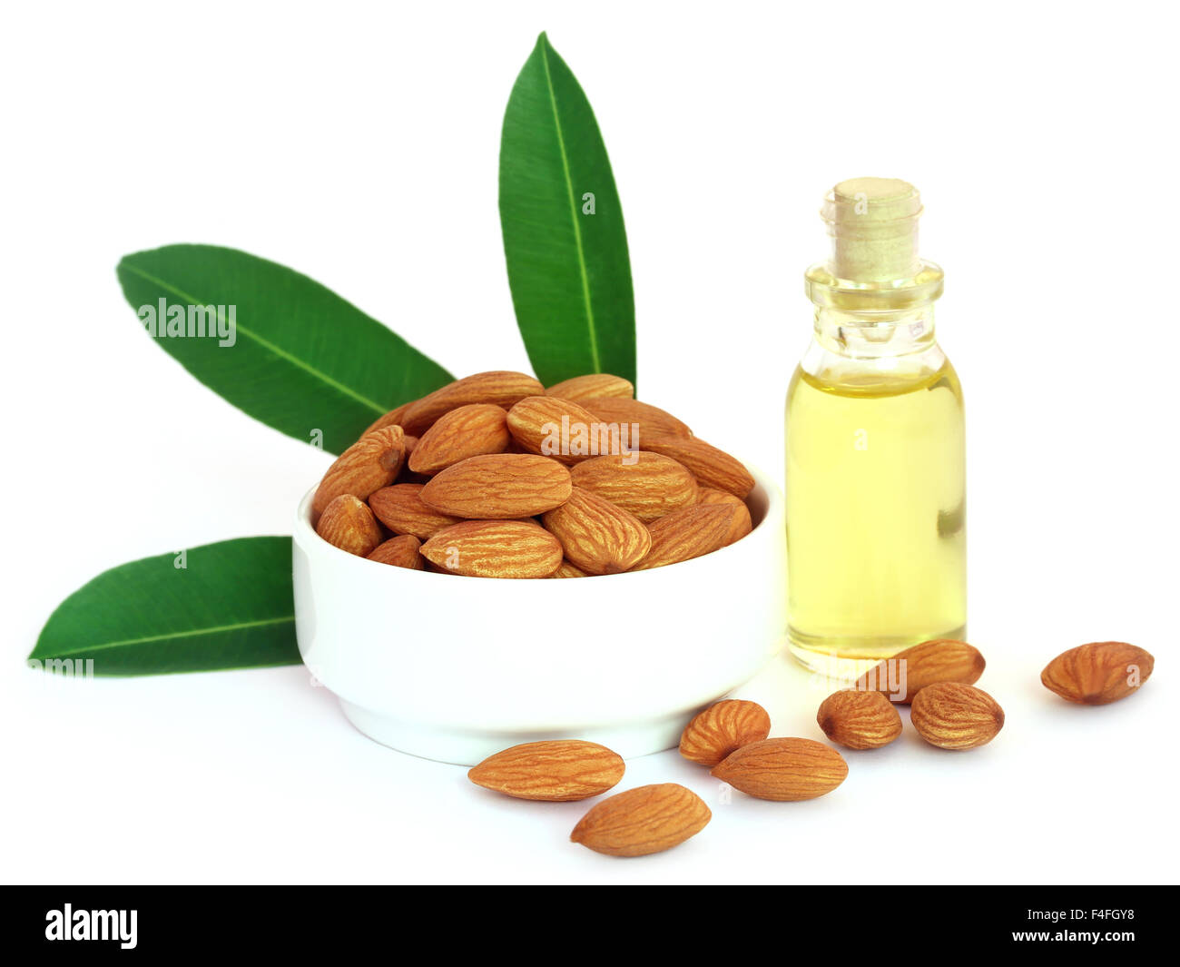Fresh almonds with oil over white background Stock Photo - Alamy