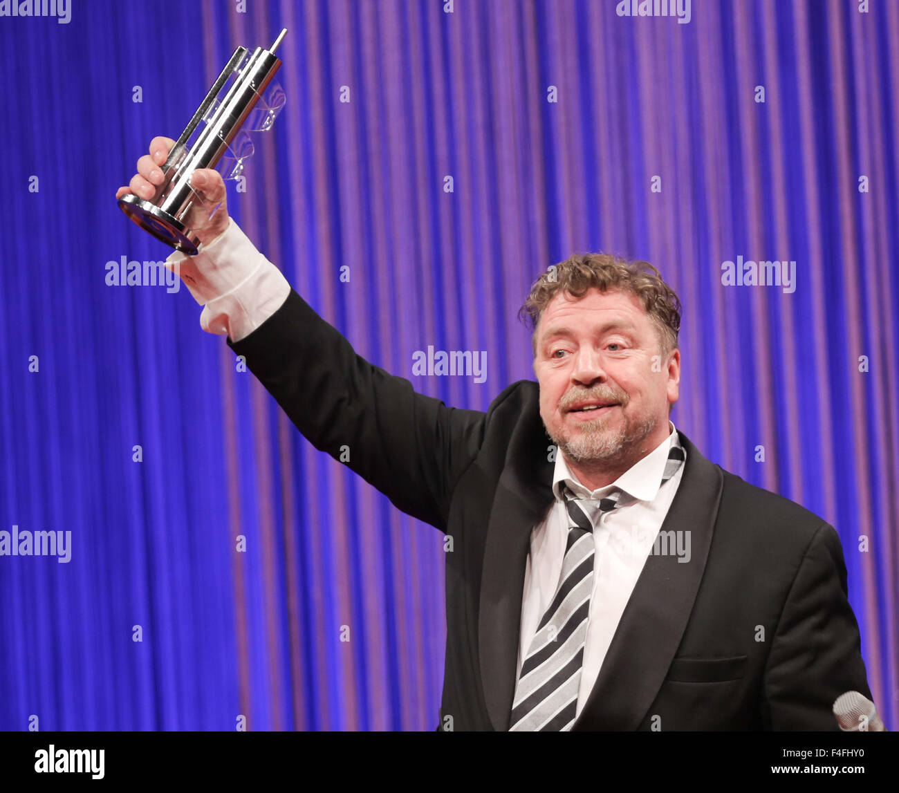 German actor Armin Rohde holds up his trophy after receiving the award ...