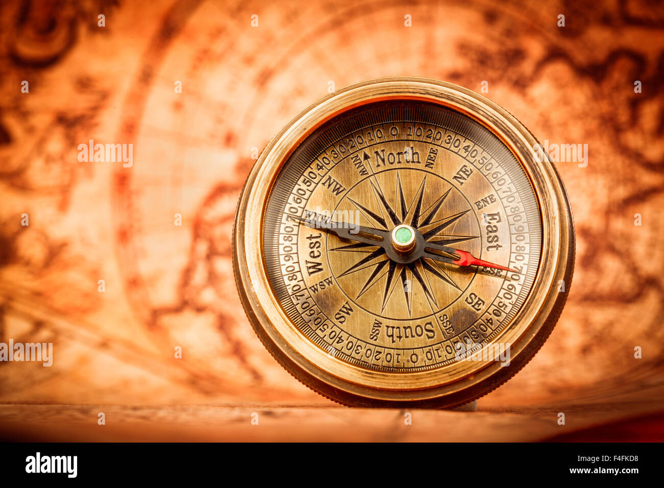Vintage still life. Vintage compass lies on an ancient world map in ...