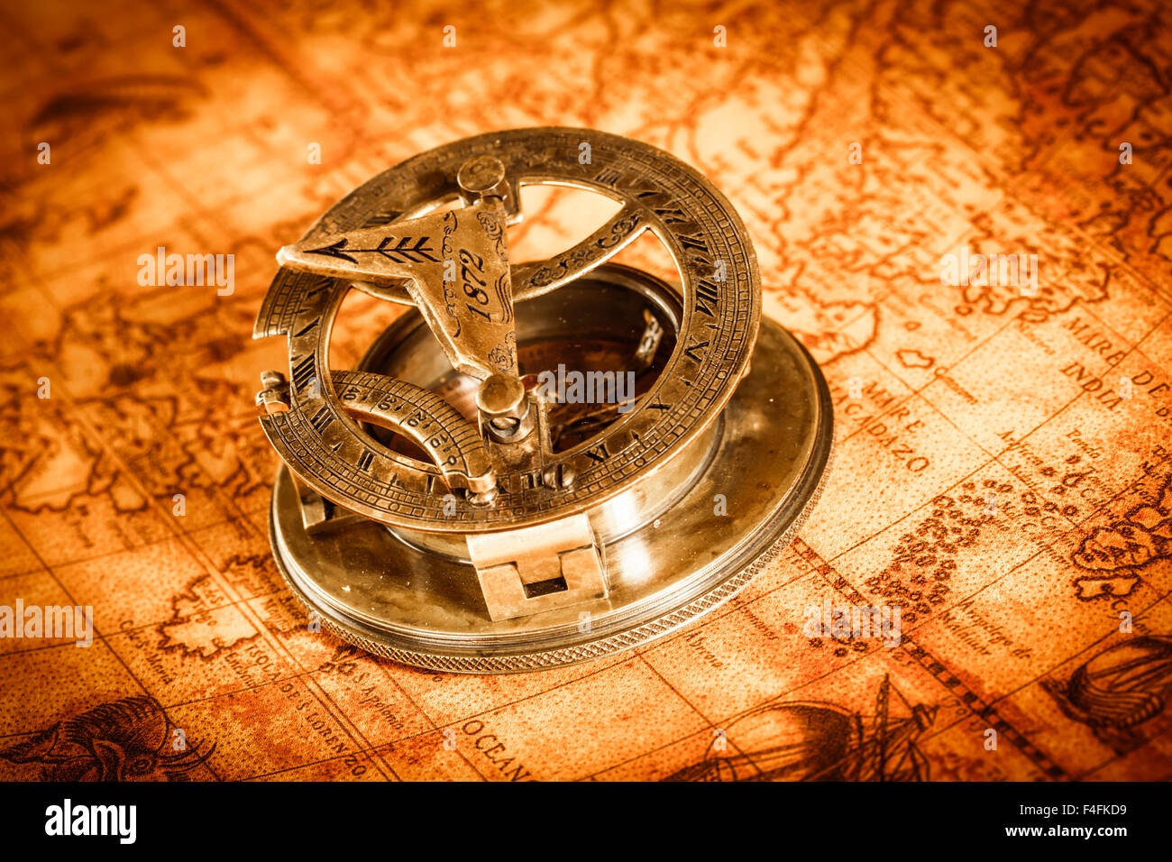 Vintage still life. Vintage compass lies on an ancient world map in ...