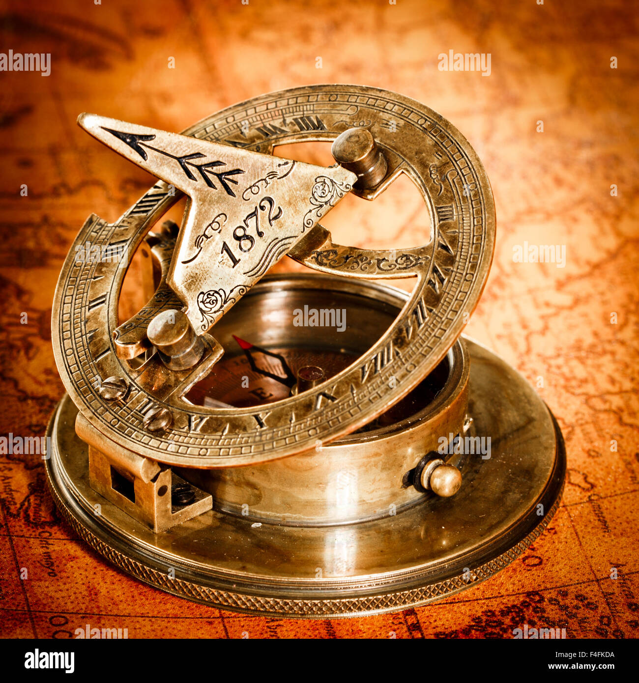 Vintage still life. Vintage compass lies on an ancient world map in ...