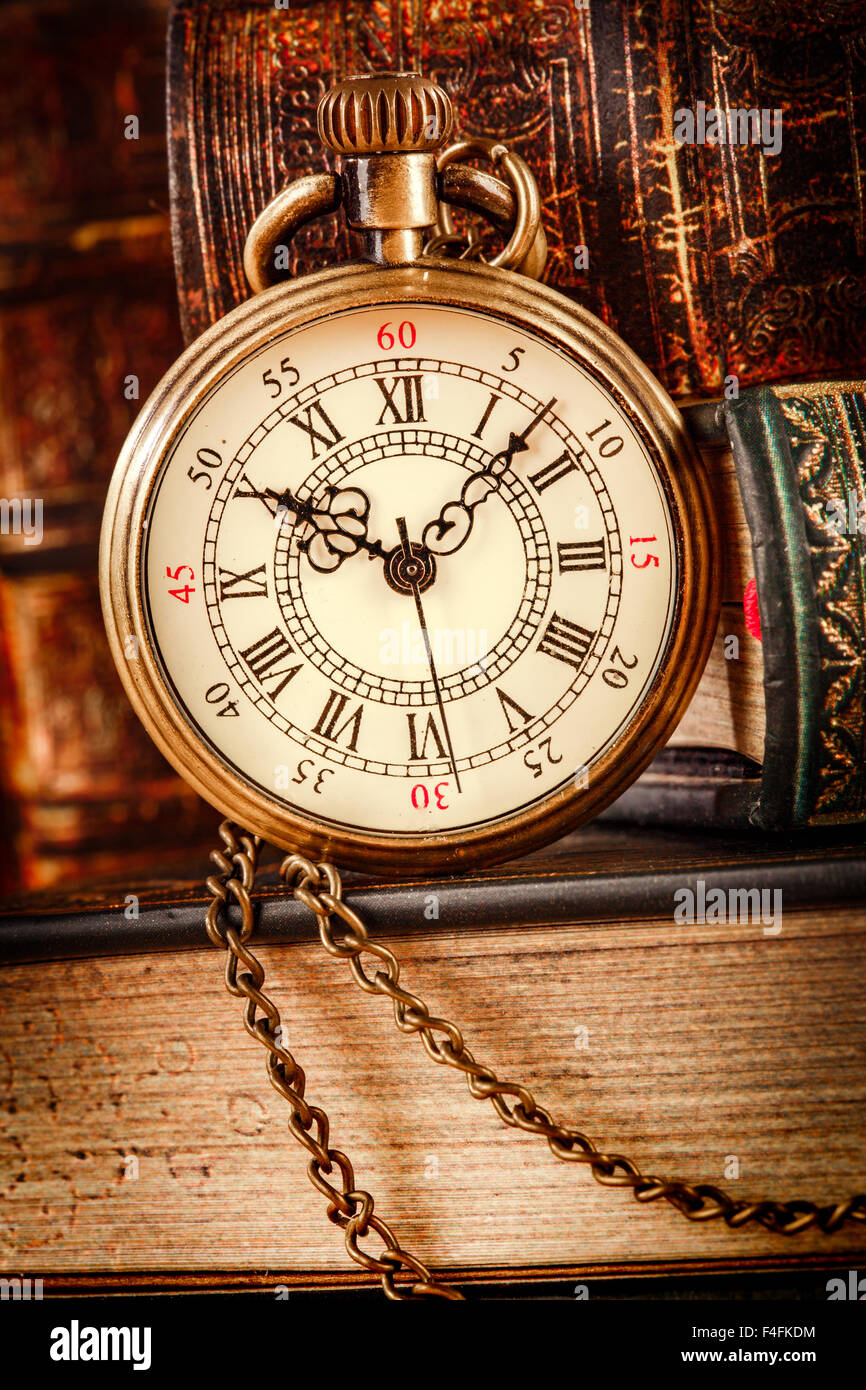Vintage Antique pocket watch on the background of old books Stock Photo ...
