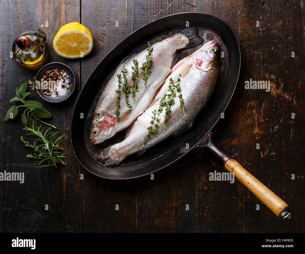 Raw uncooked Trout fish with spices and herbs on pan on dark wooden ...