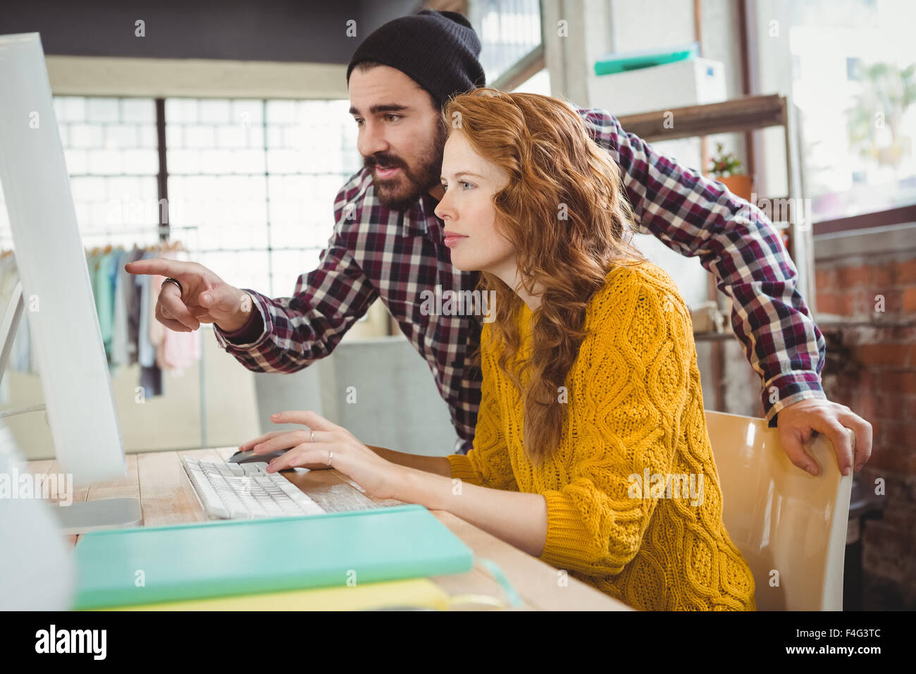 Man pointing at computer and showing to colleague Stock Photo - Alamy