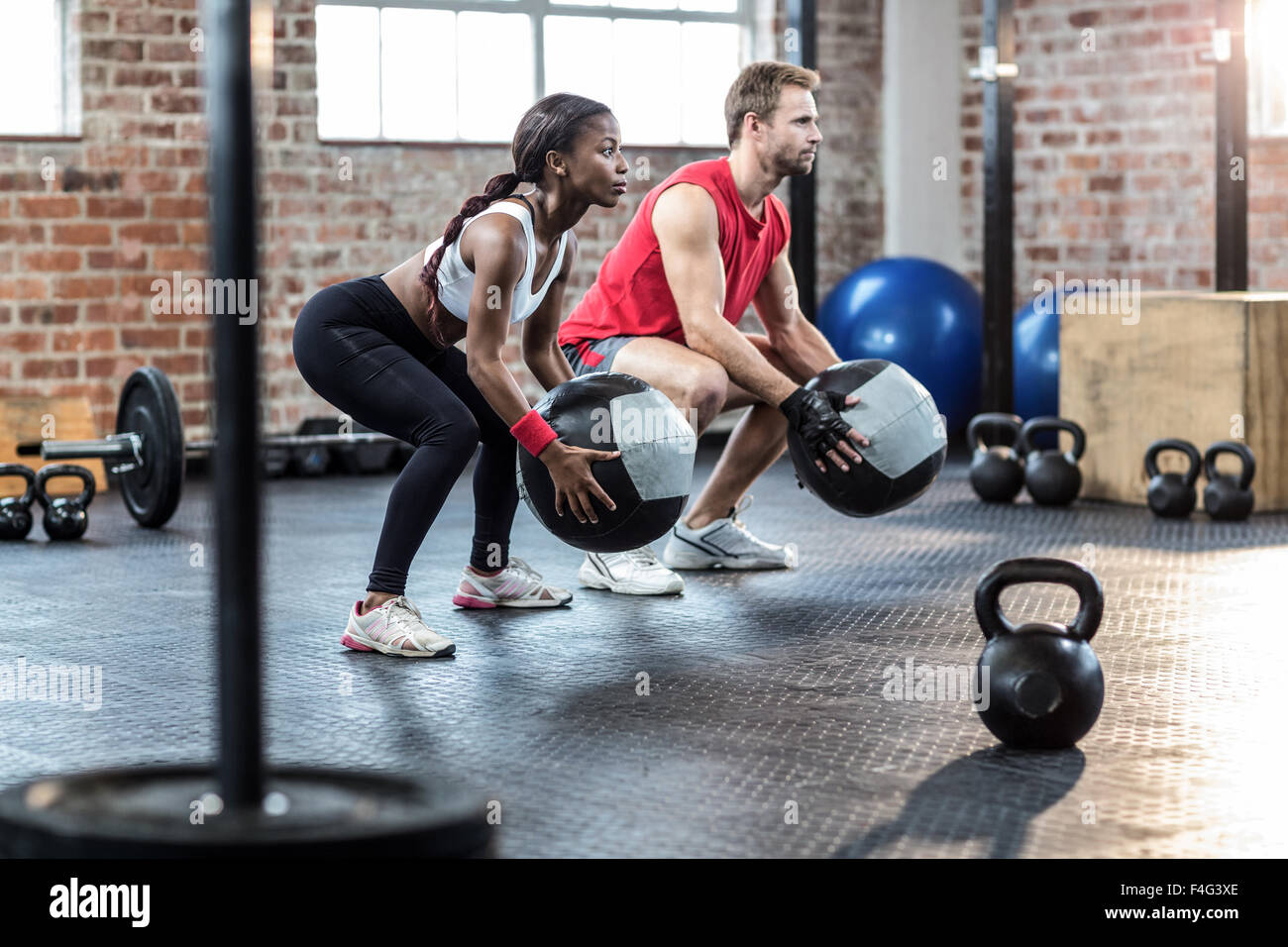 Muscular couple doing ball exercise Stock Photo - Alamy