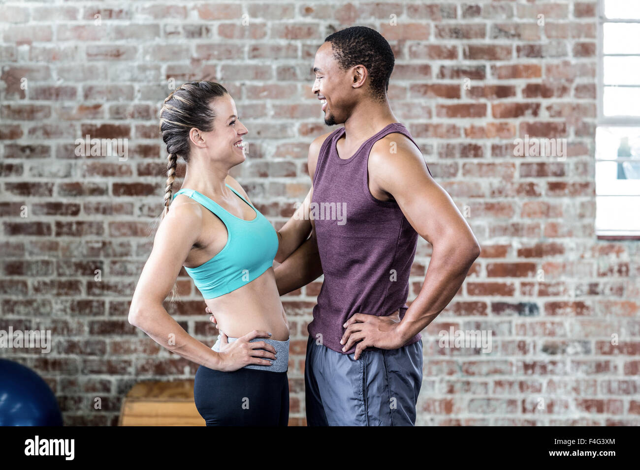 Fit couple smiling and talking together Stock Photo - Alamy
