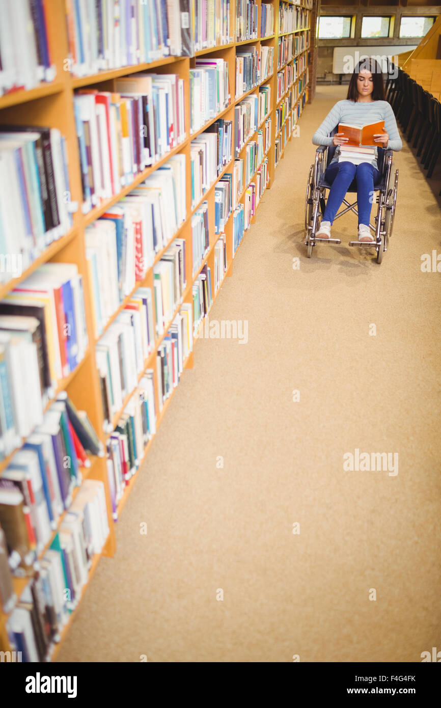Disabled female student reading book on wheelchair Stock Photo - Alamy