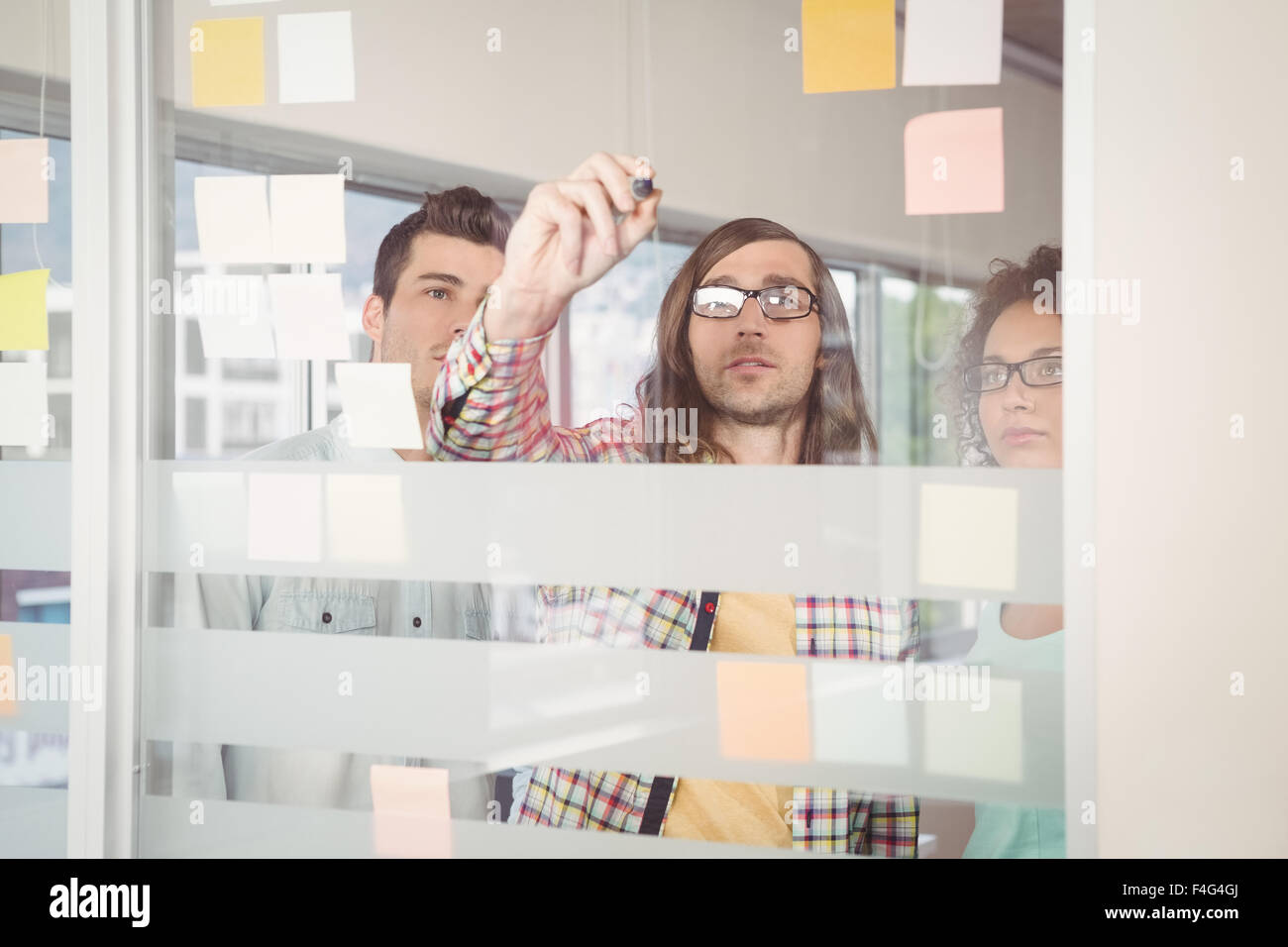 Creative businessman writing on glass in office Stock Photo - Alamy