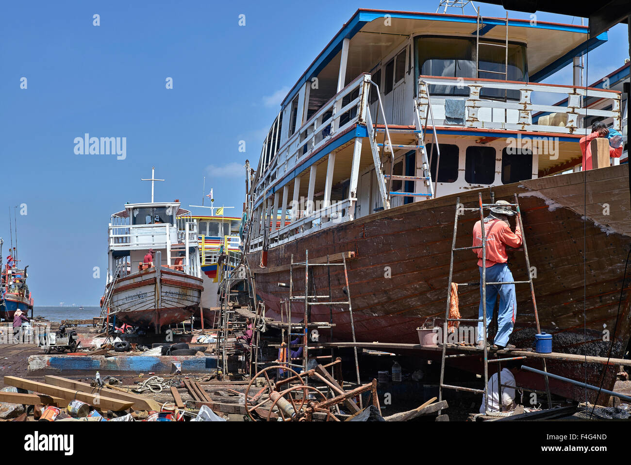 Boat repair yard. Traditional wooden Thai fishing boats undergoing dry ...