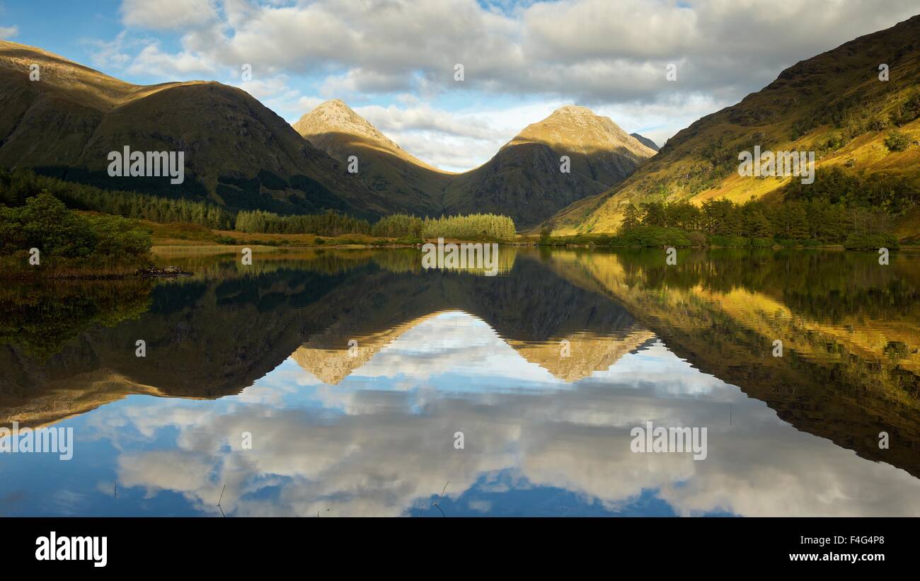 Golden light from the dipping sun hits the banks of a still Lochan Urr ...