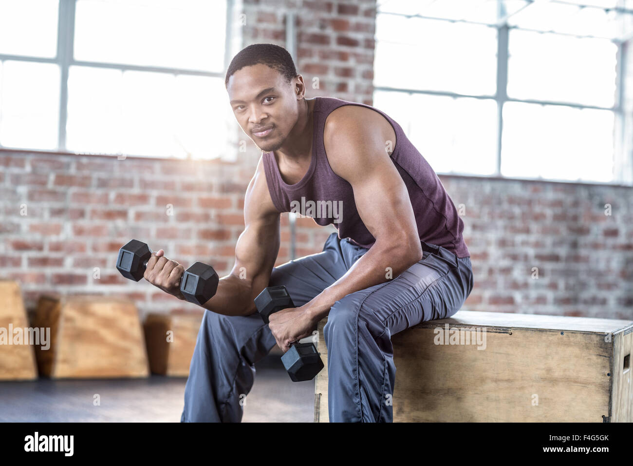 Smiling muscular man lifting dumbbell Stock Photo - Alamy