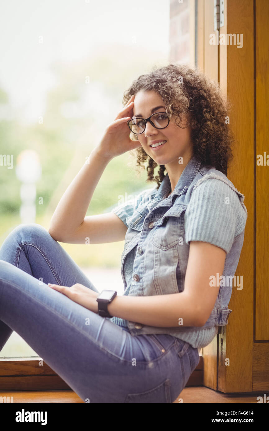 Pretty student sitting by window smiling at camera Stock Photo - Alamy