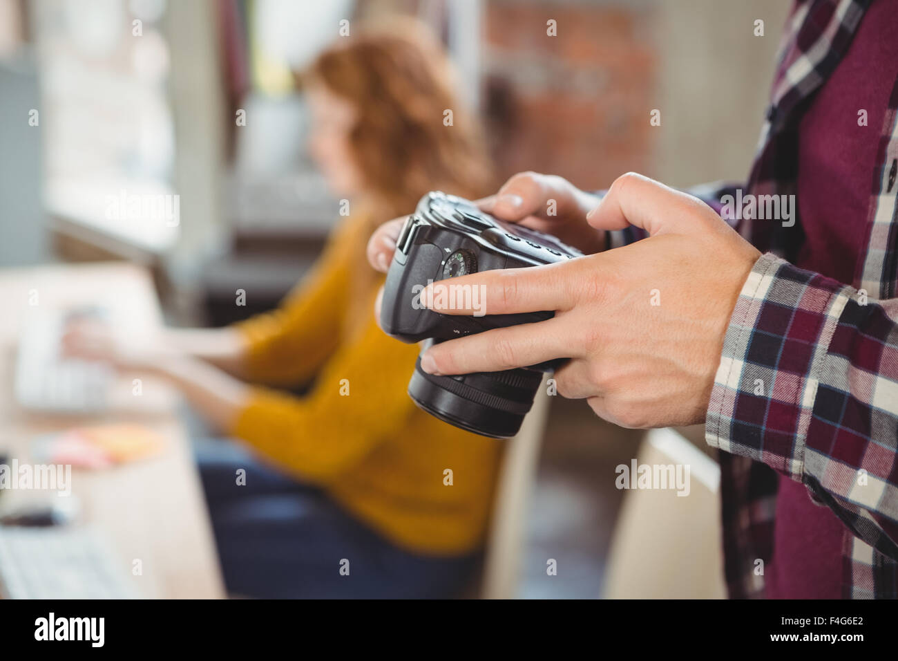 Cropped hands holding camera at office Stock Photo - Alamy