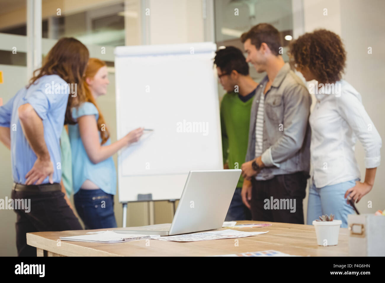 Creative businesswoman explaining colleagues Stock Photo - Alamy