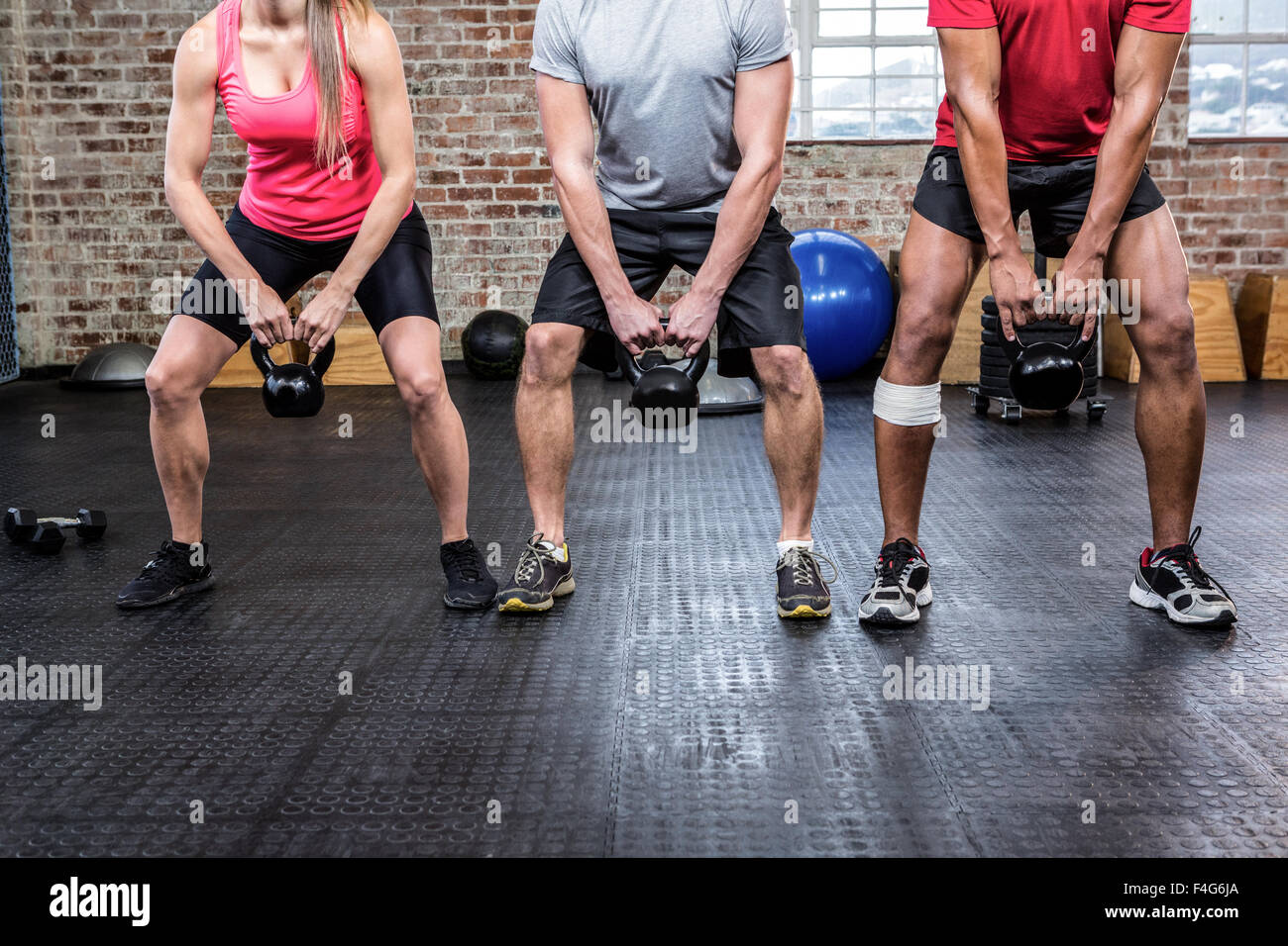 Fit people lifting kettlebells together Stock Photo - Alamy