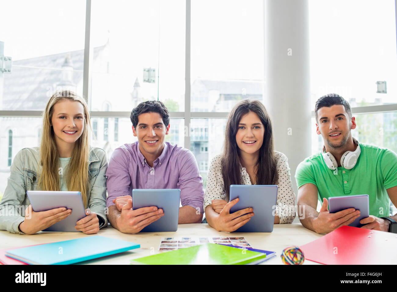 Students using tablets sitting in a line Stock Photo - Alamy