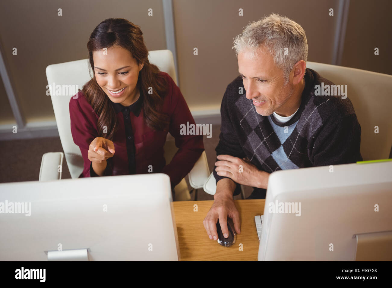 Businesswoman pointing at computer in office Stock Photo - Alamy