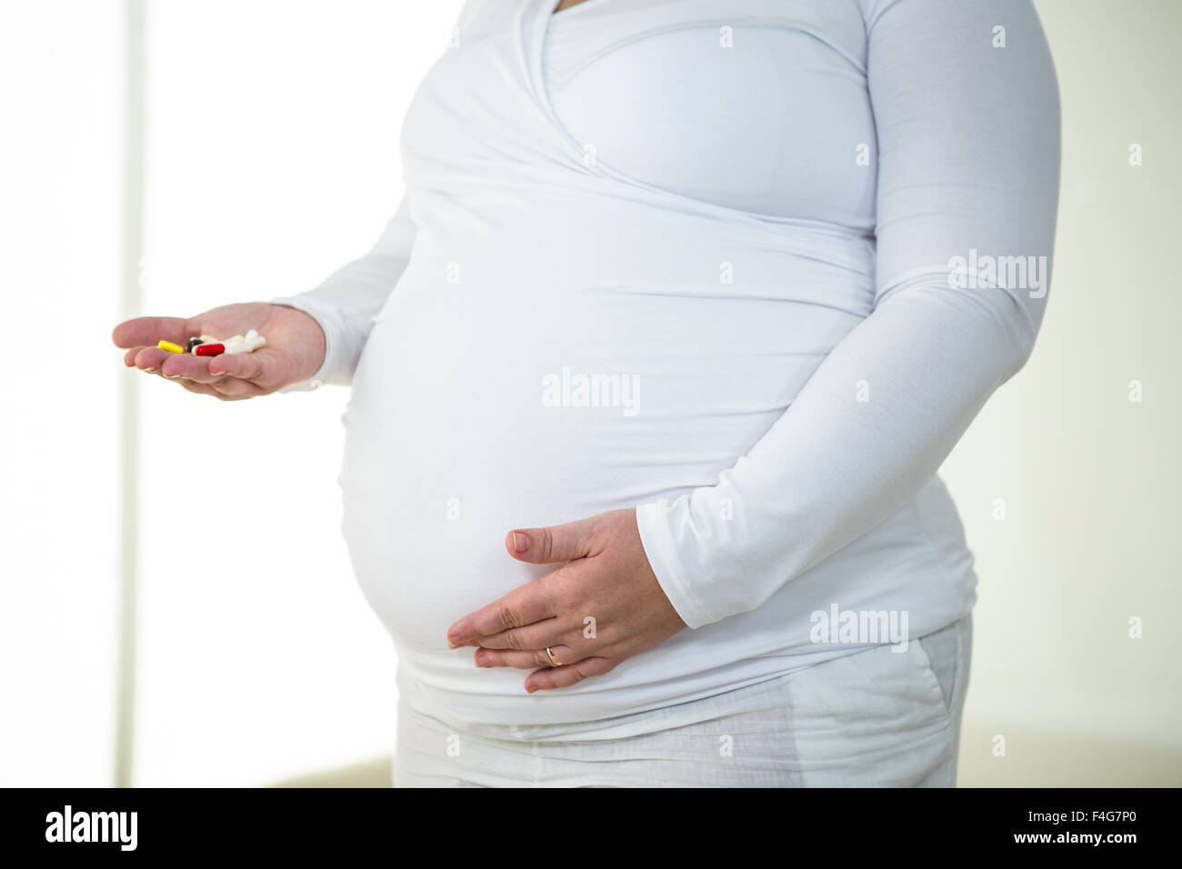 Pregnant woman taking medical pill Stock Photo - Alamy